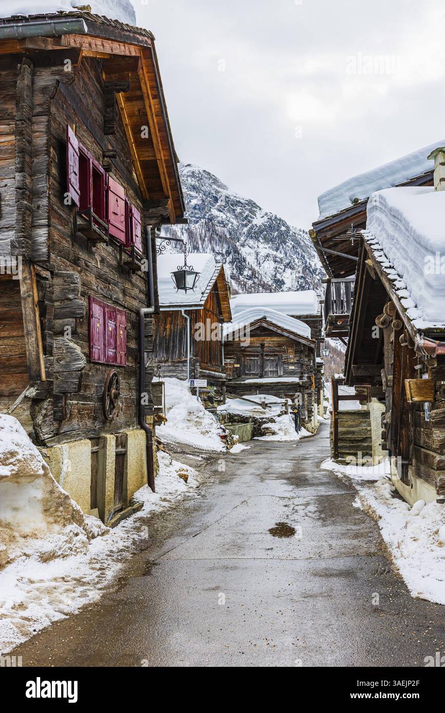 Street with historic old snow-covered wooden houses, mountain village ...