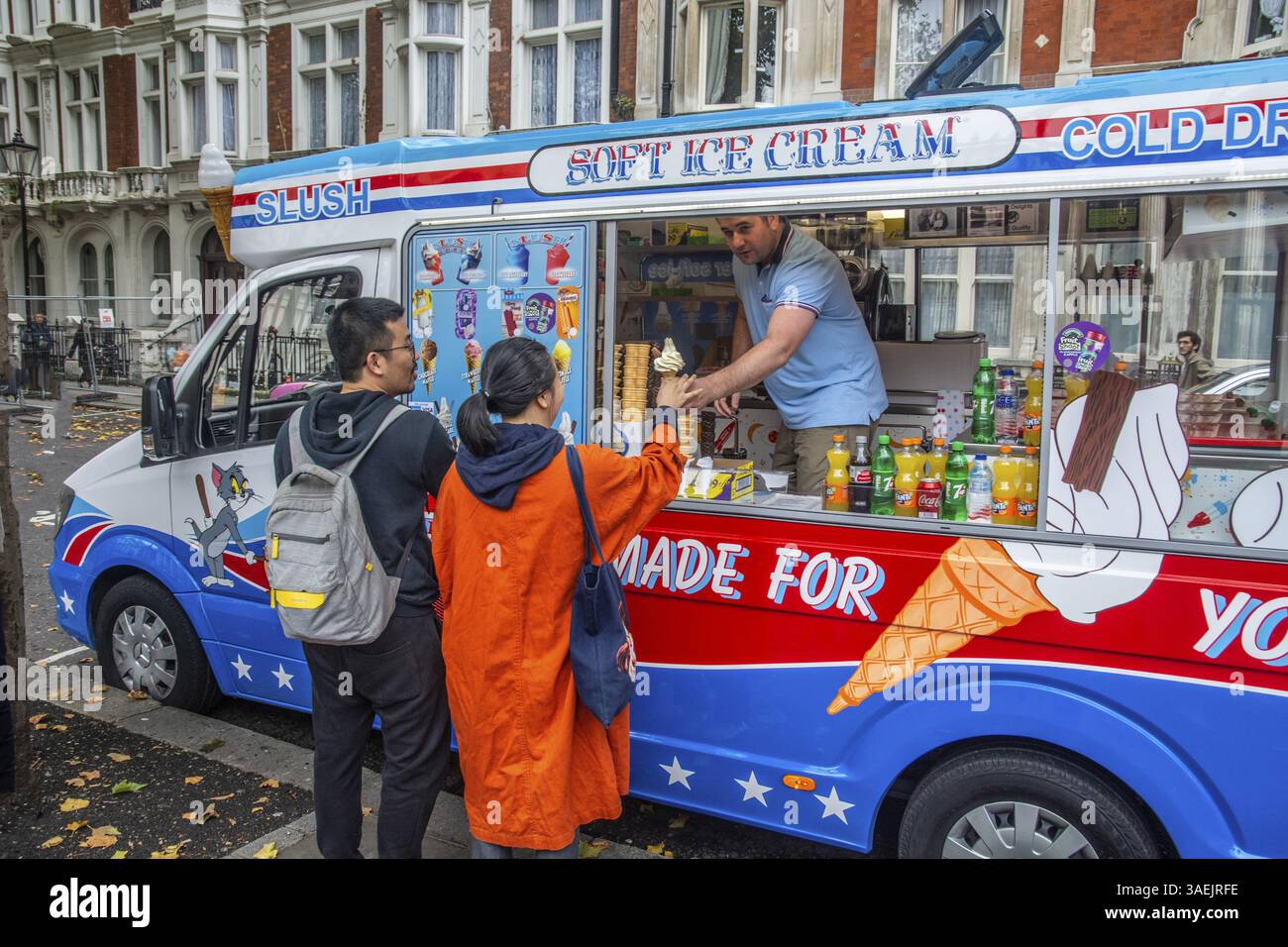 Tourists buying ice cream from a mobile ice cream stall on the street ...