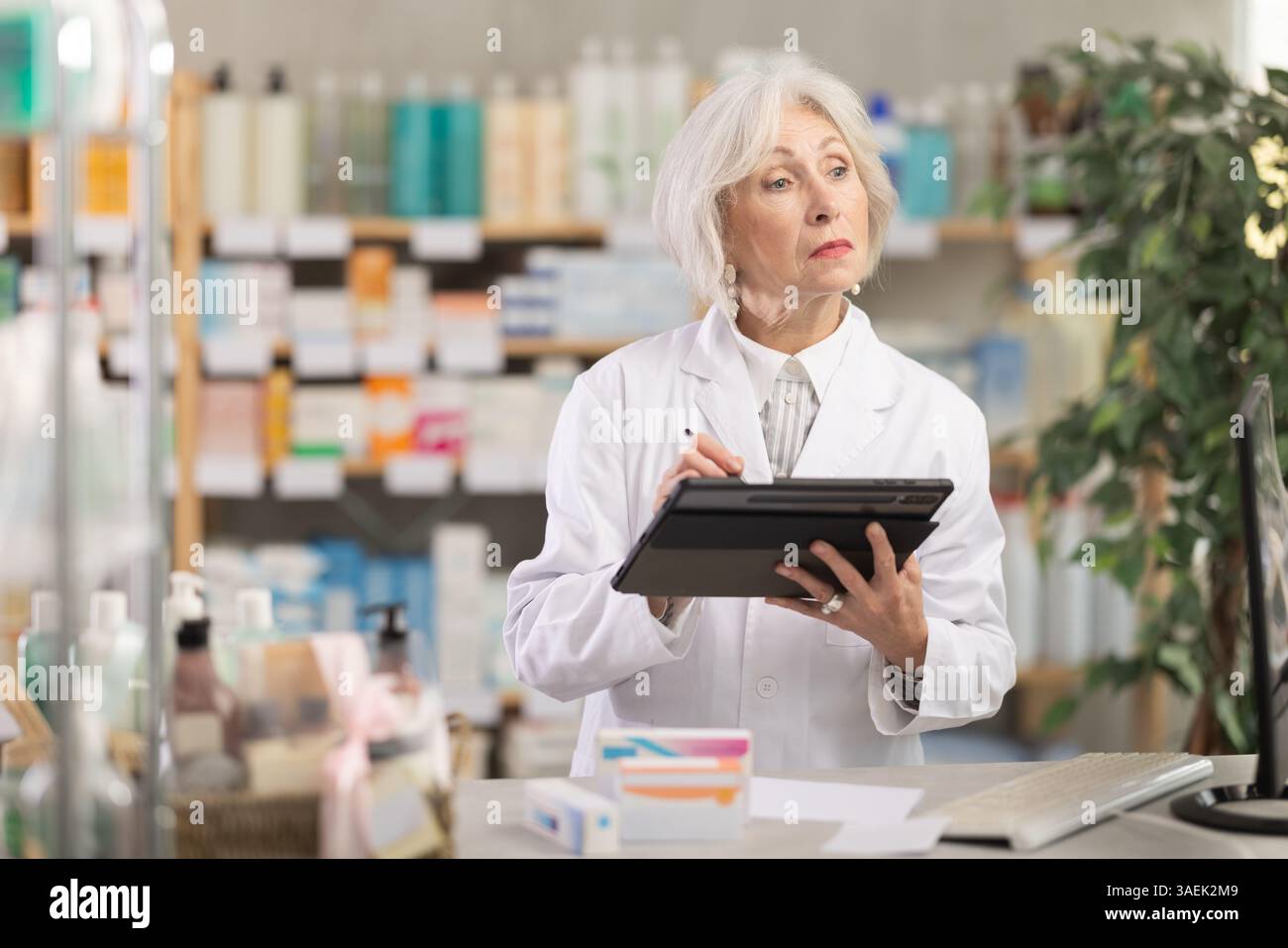 Female pharmacist conducting inventory with tablet Stock Photo - Alamy