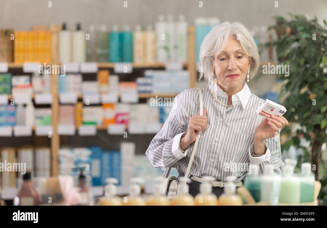 Elderly woman in summer clothes scans code on package of paracetamol ...
