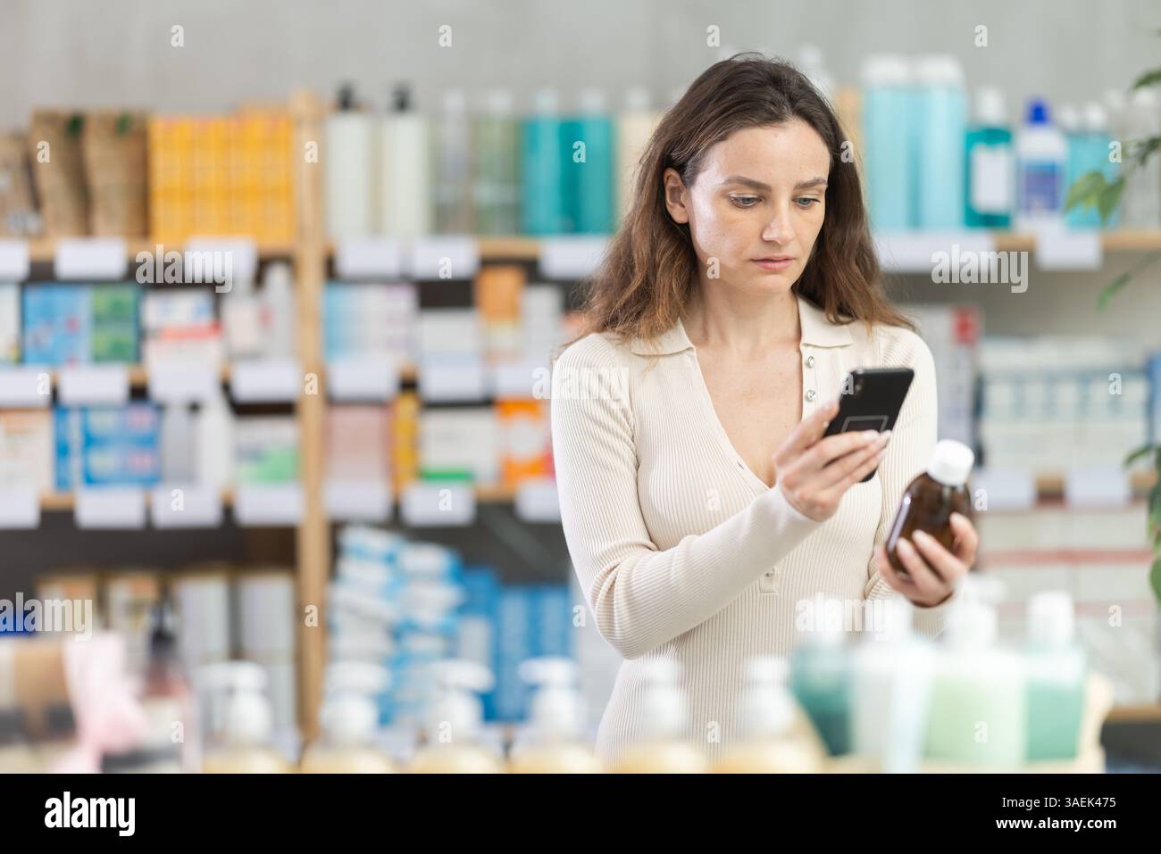 Adult woman scanning qr code of syrup Stock Photo - Alamy