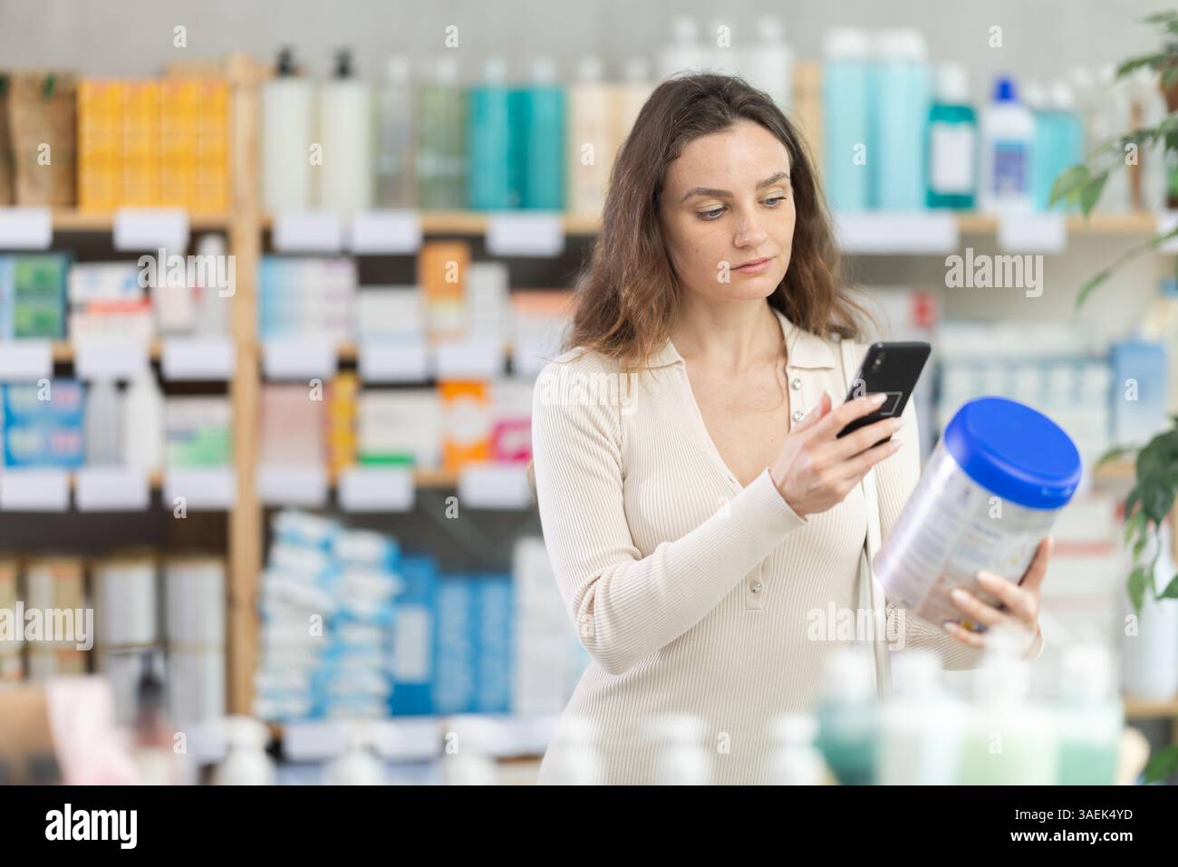 Adult woman scanning qr code of baby formula Stock Photo - Alamy