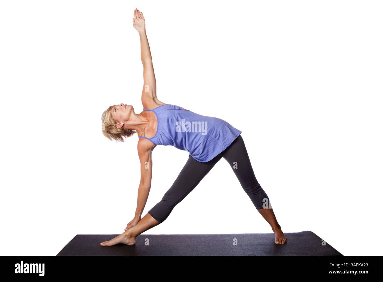 Beautiful healthy woman doing Triangle Utthita Trikonasana yoga pose ...