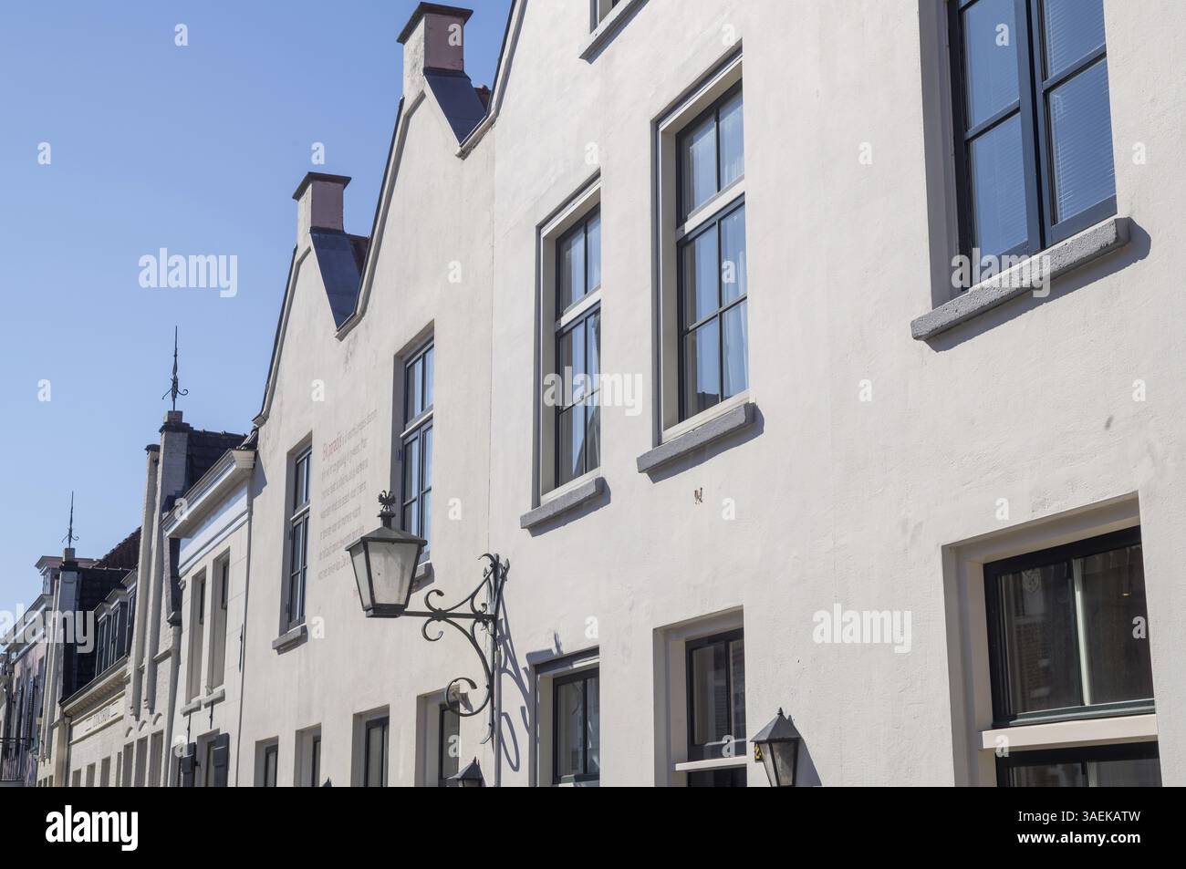 White facades of traditional dutch houses with gable roofs and street ...