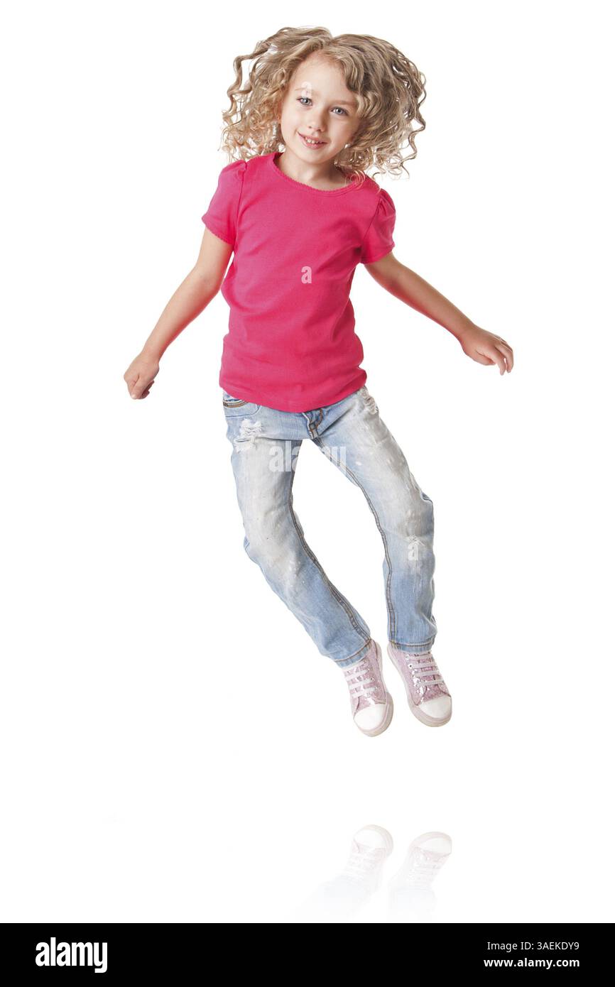 Cute happy smiling jumping of joy girl with heels together in pink ...