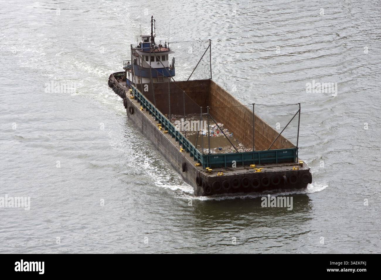 Empty boat for transporting garbage cruising in a river, used for waste ...