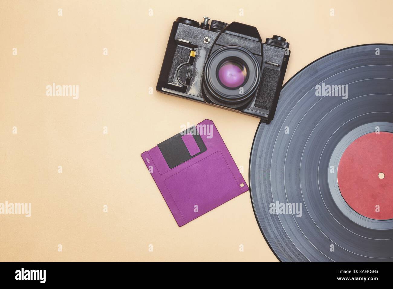 An old vinyl record, a film camera and a floppy disc for a computer are ...