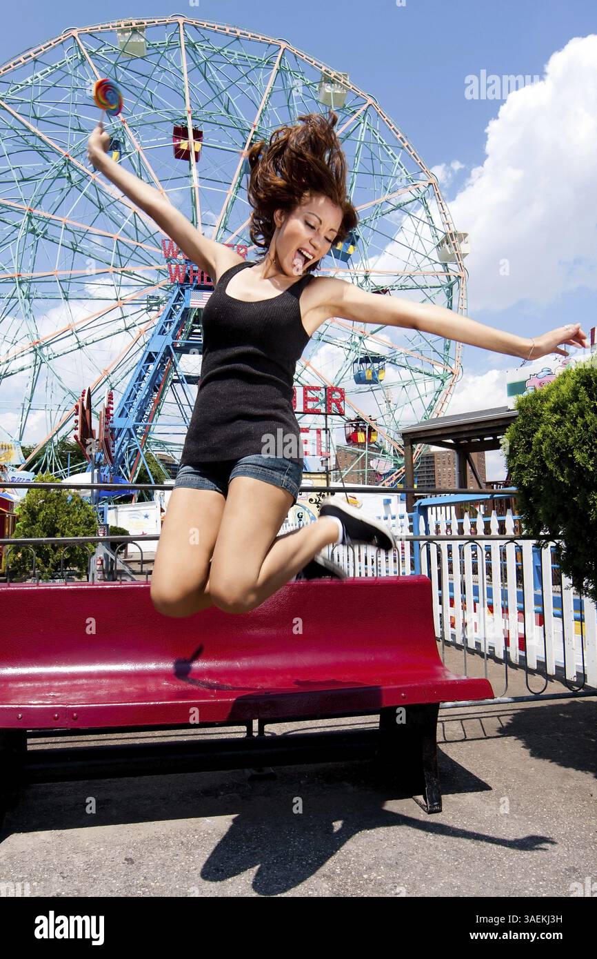 Beautiful fun happy girl jumping with colorful lollipop at the Wonder ...