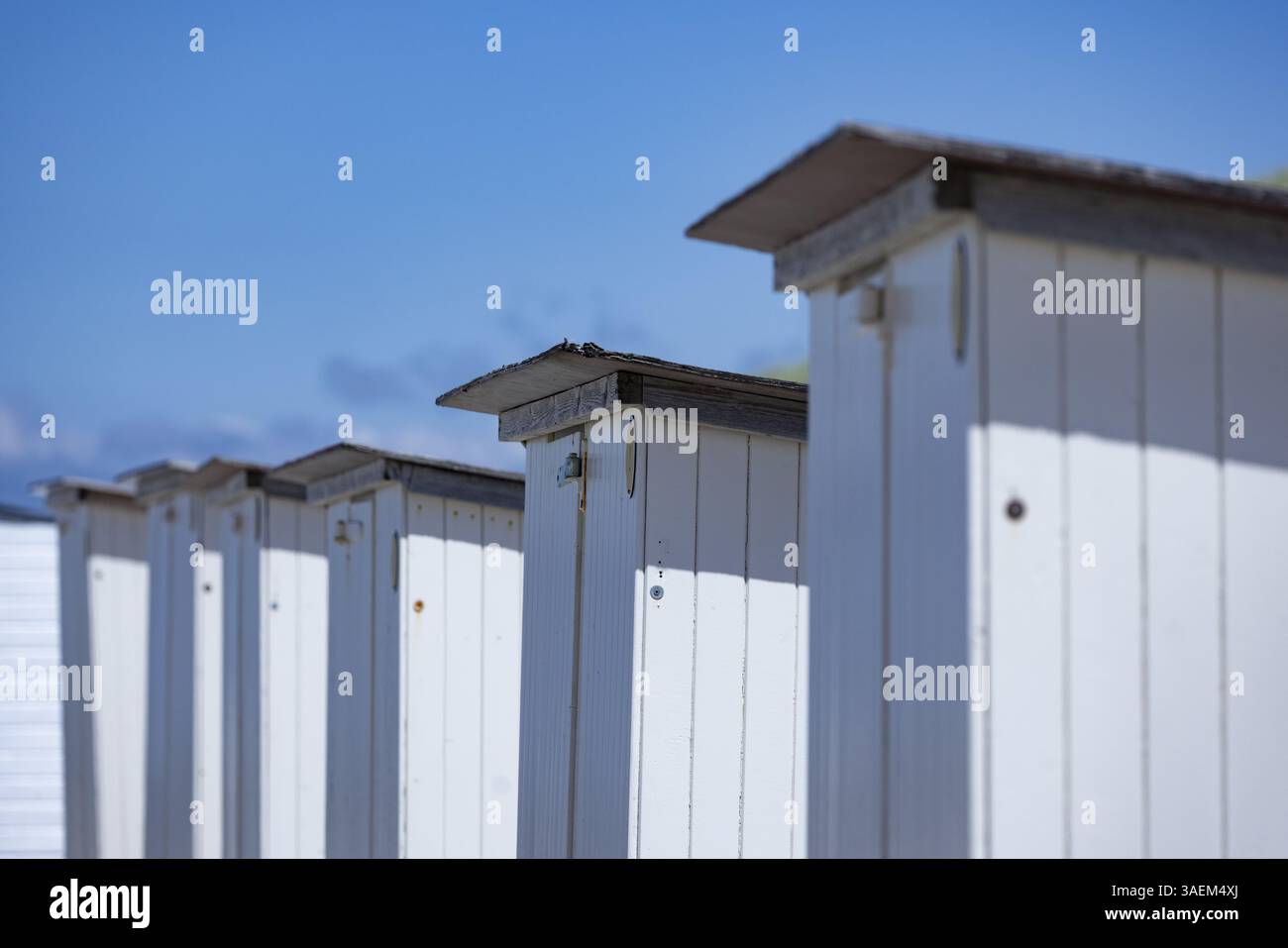 A row of white beach huts under a clear blue sky, Groede, Zeeland ...