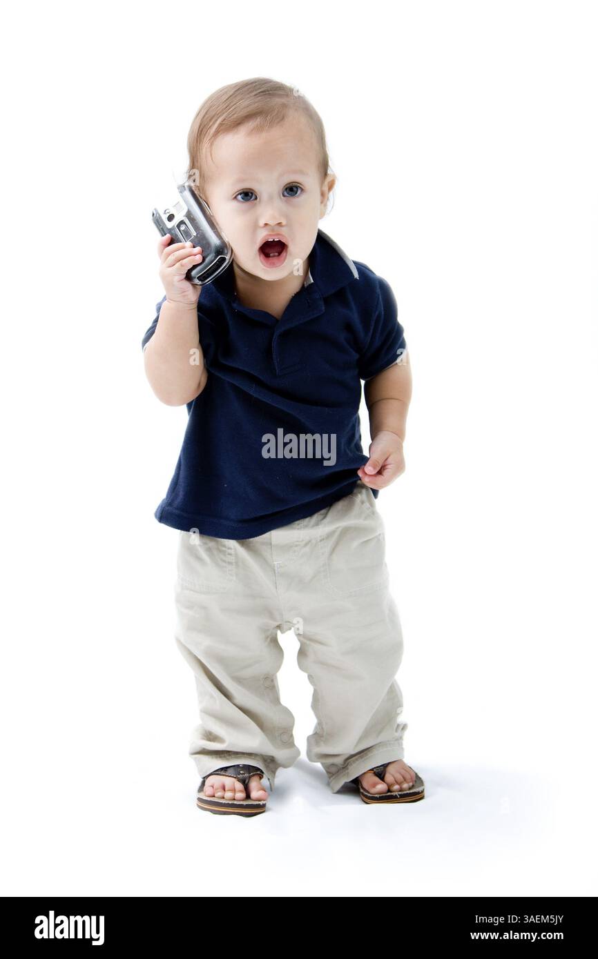 Baby standing with phone in hand calling and mouth open, isolated, New ...