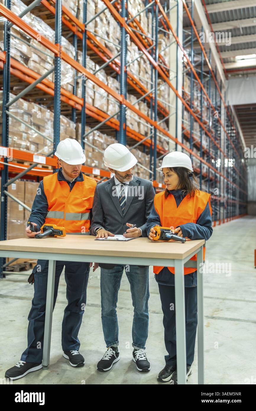 Warehouse workers and manager meeting, discussing logistics and ...