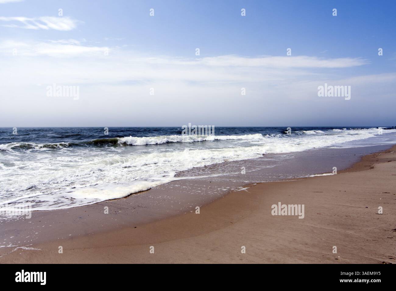 Beautiful beach with ocean sea crashing rolling waves under a blue sky ...