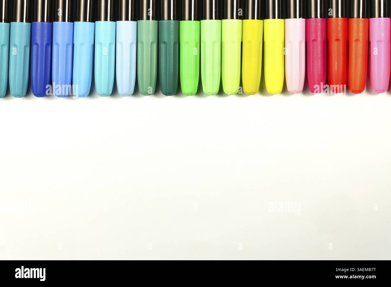 Colored markers placed in a row on a white background with copy space ...