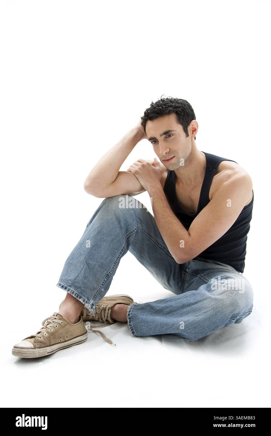 Handsome Caucasian guy wearing black tank top and jeans sitting on ...