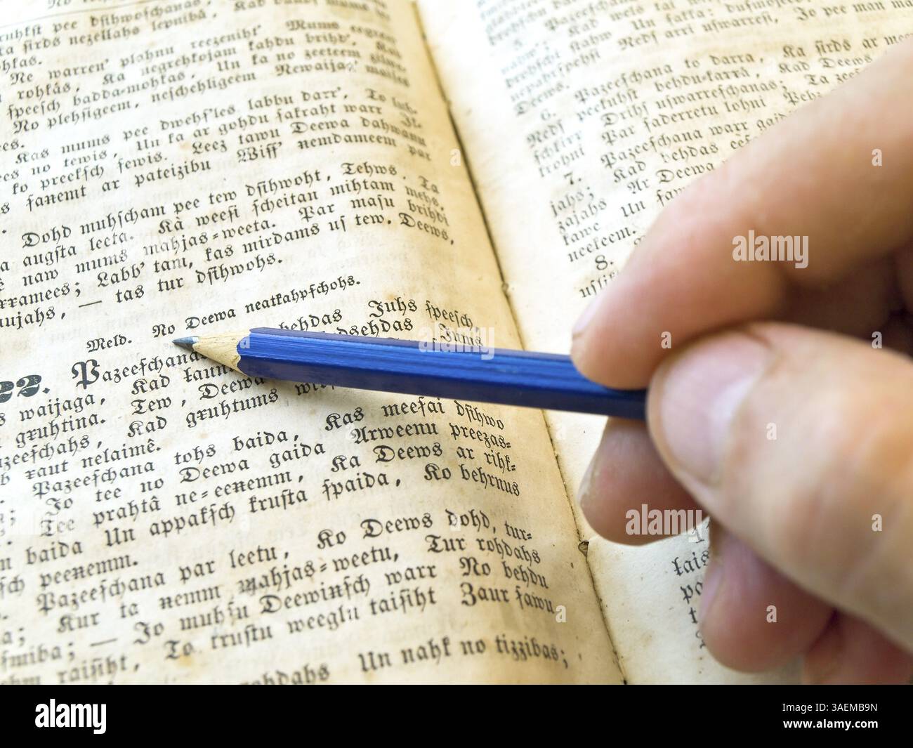 Reading old open book with blue pencil Stock Photo - Alamy