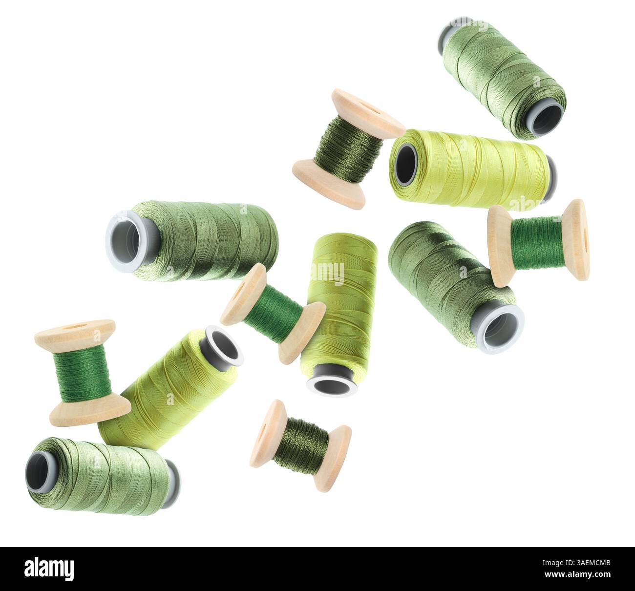 Many sewing threads in different shades of green flying on white ...