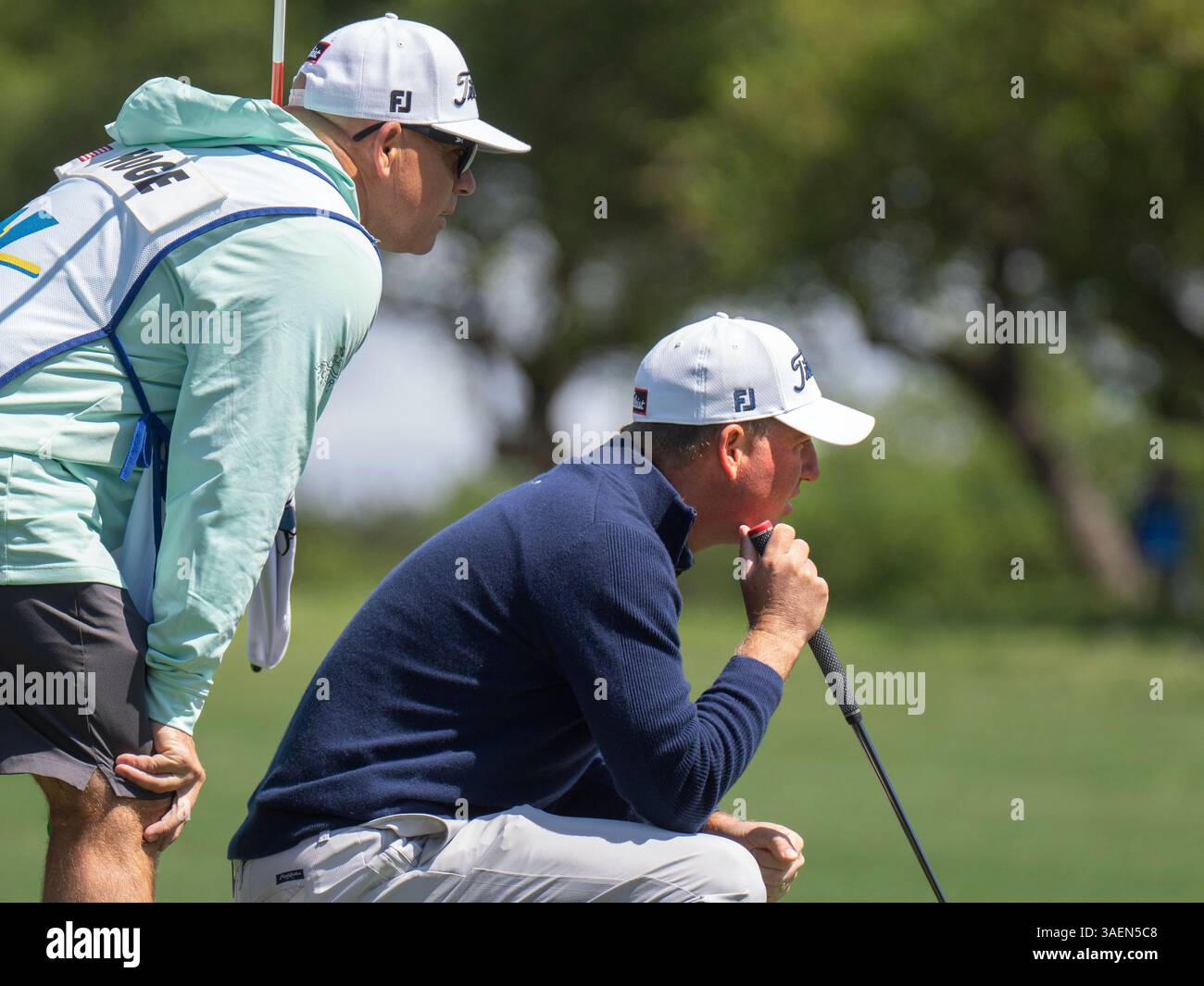 Tom Hoge, right, looks over his line with caddie James Edmondson, left ...