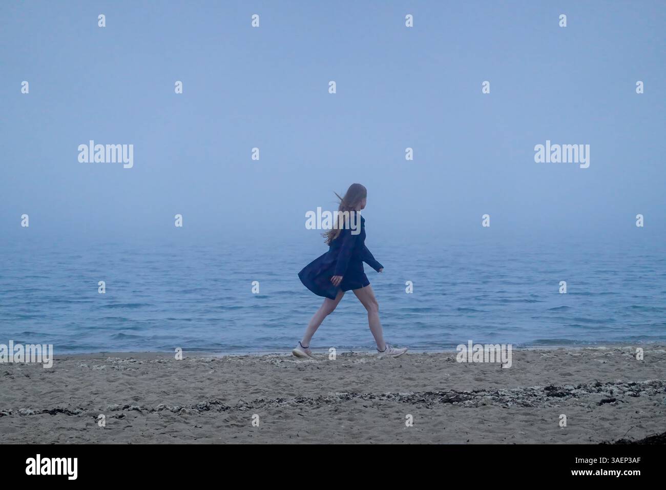 Solitary Stroll: Woman Walking on Foggy Beach - Gigapixel Stock Photo ...