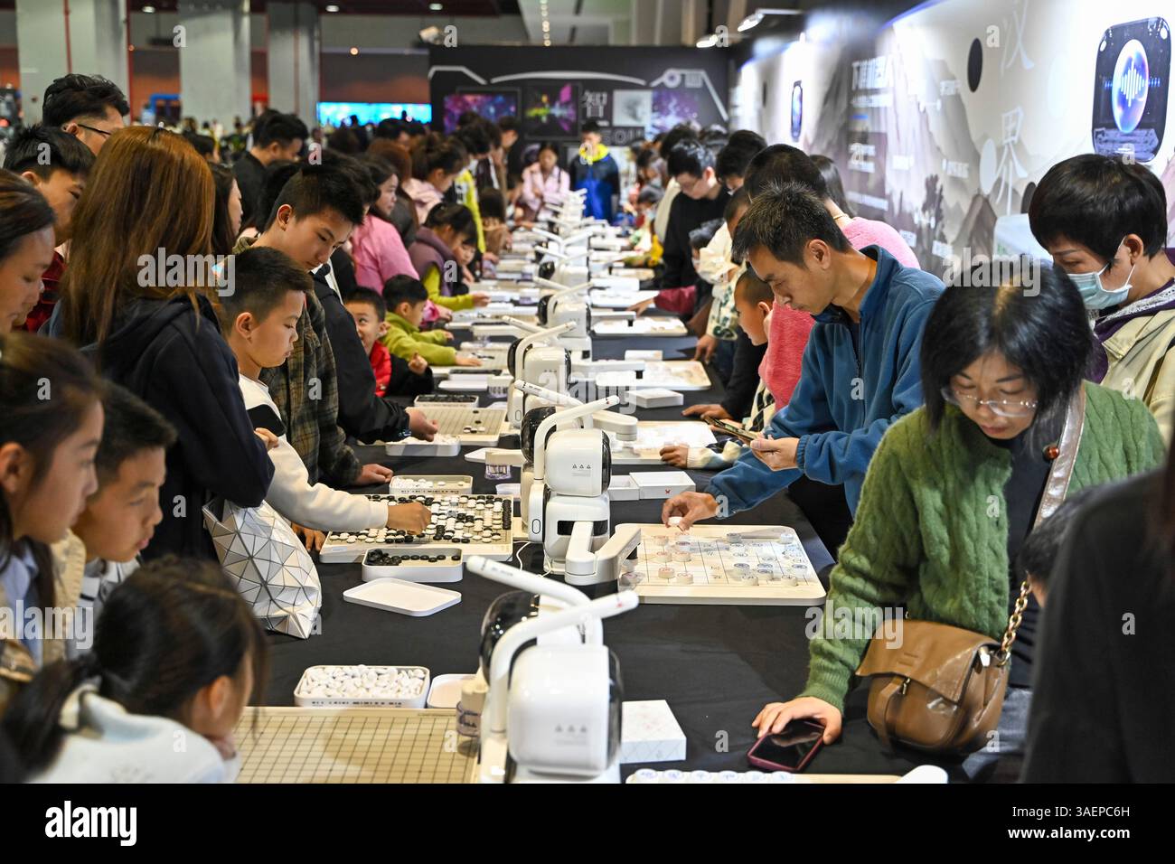 Guangzhou,China.5th April 2025. Visitors play Chinese chess with robots ...