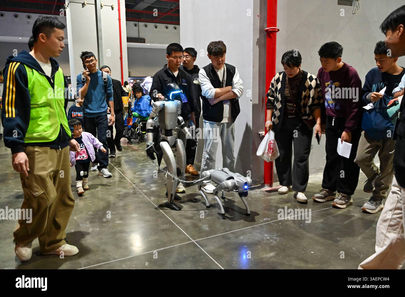 Guangzhou,China.5th April 2025. A humanoid robot walks with a quadruped robot during the 2025 ...