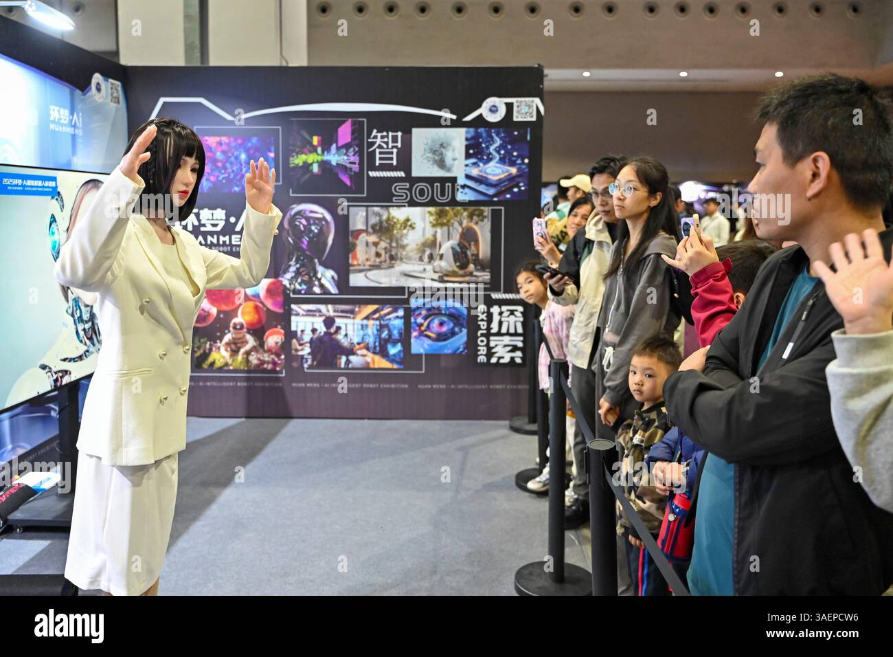 Guangzhou,China.5th April 2025. Visitors interact with a lifelike bionic robot during the 2025 ...