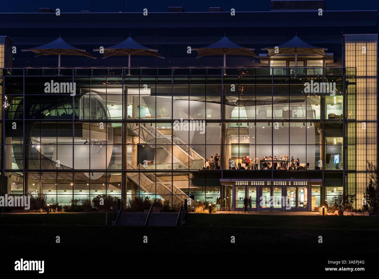 Modern Glass Building at Night with People gathered Inside Stock Photo ...