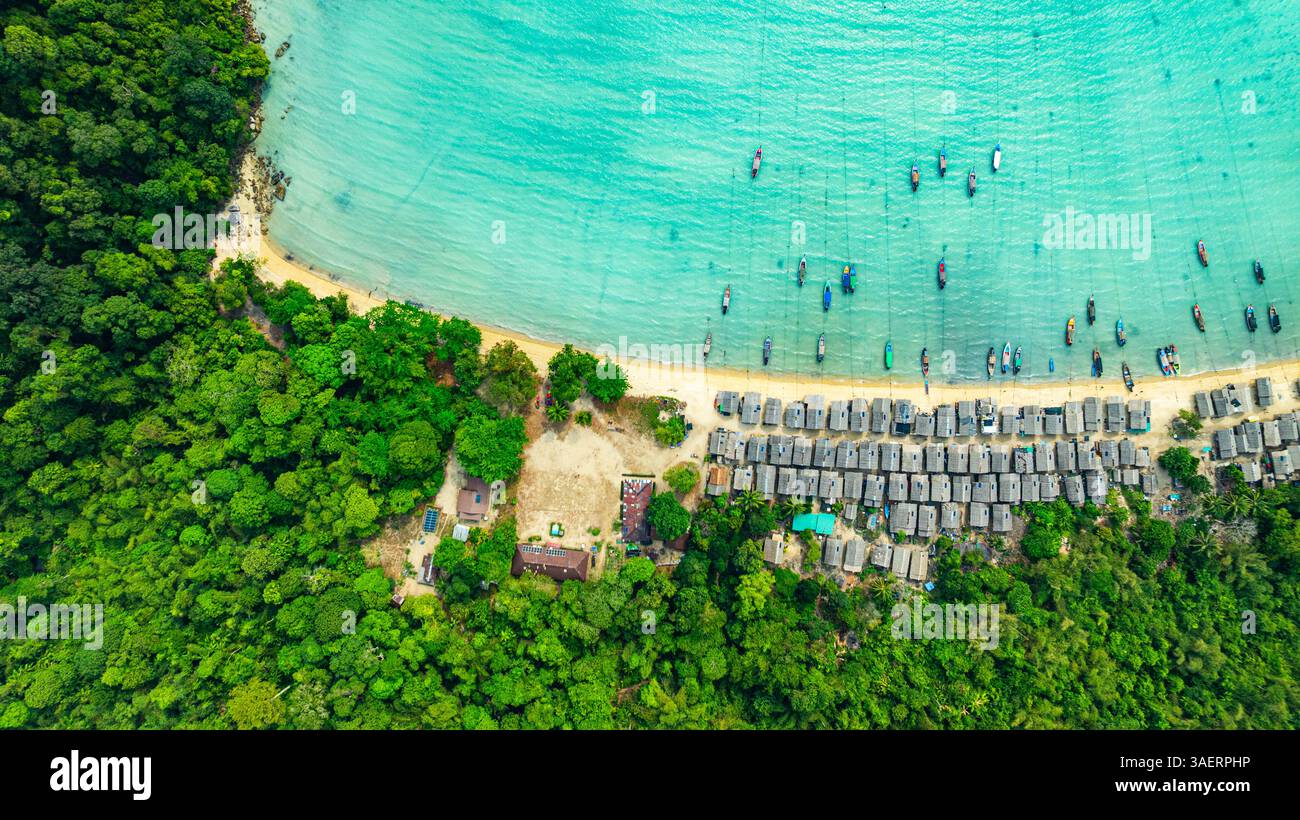 A stunning aerial view of a tropical beach village with rows of small ...