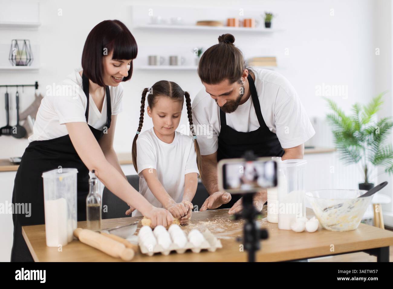 Caucasian family cooking together and vlogging in kitchen setting Stock ...