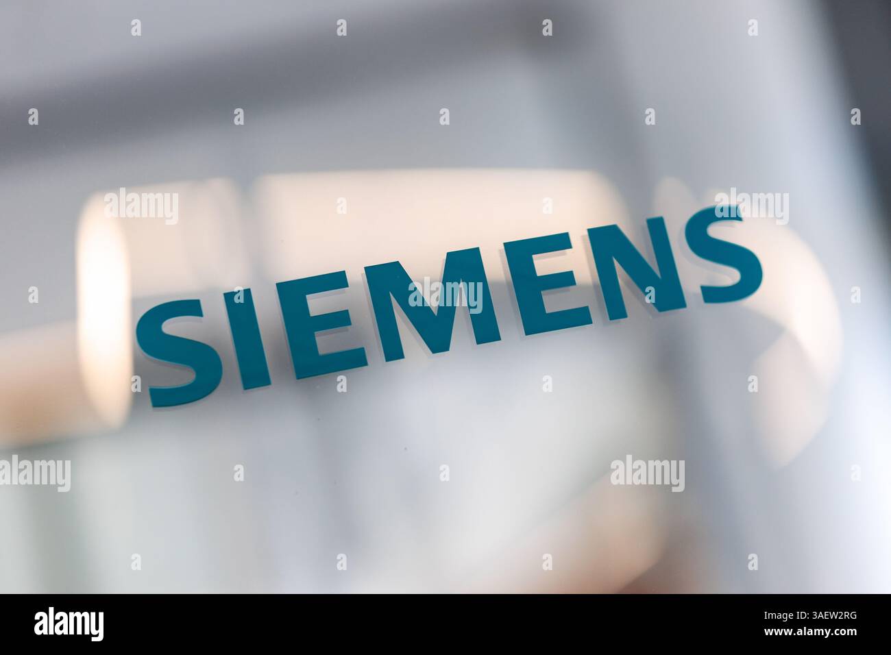 06 April 2025, Bavaria, Munich: The lettering and logo of Siemens AG can be seen on a pane of ...