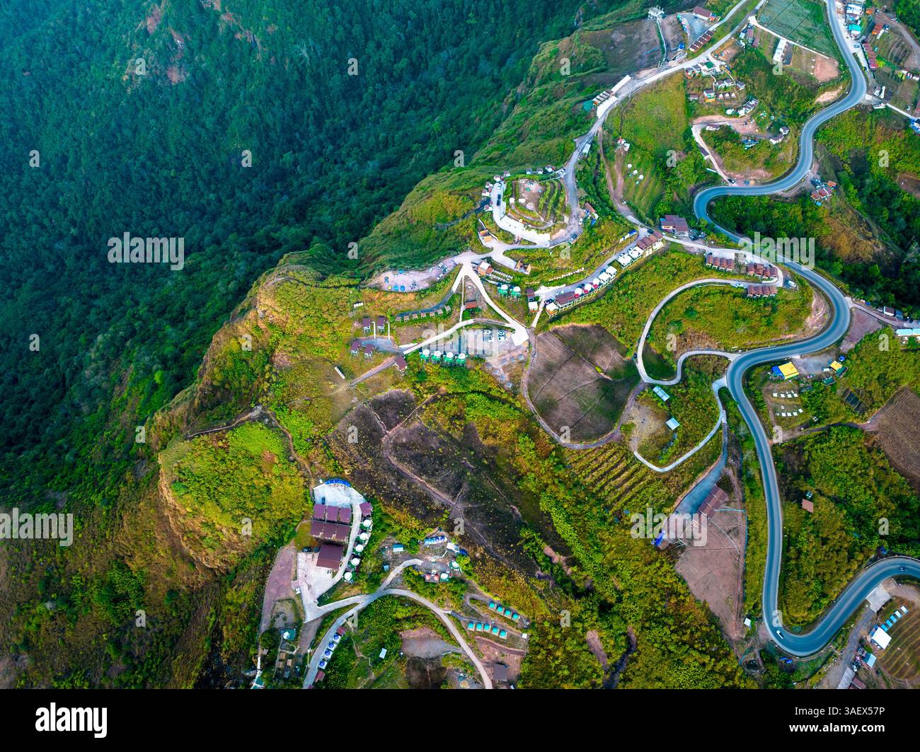 aerial view of a winding mountain road surrounded by lush greenery ...