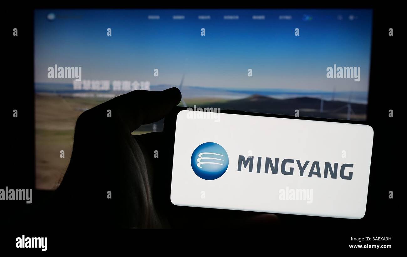 In this photo illustration, a person is holding a mobile phone with the logo of Chinese company ...