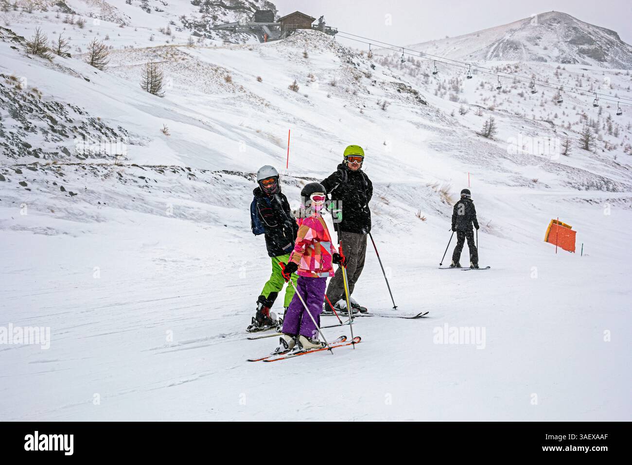 family skiing at italian alpine ski resort in bad weather. school ...
