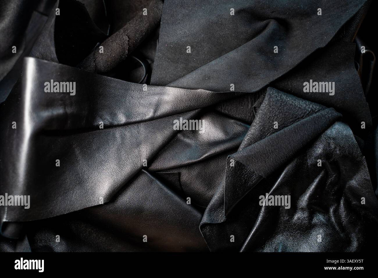 Black leather scraps from production close-up Stock Photo - Alamy