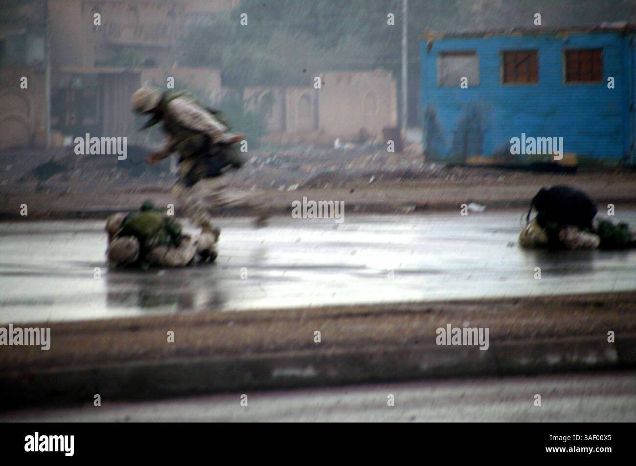 Nov 09, 2004; Fallujah, Iraq; A Marine runs for cover after two others ...