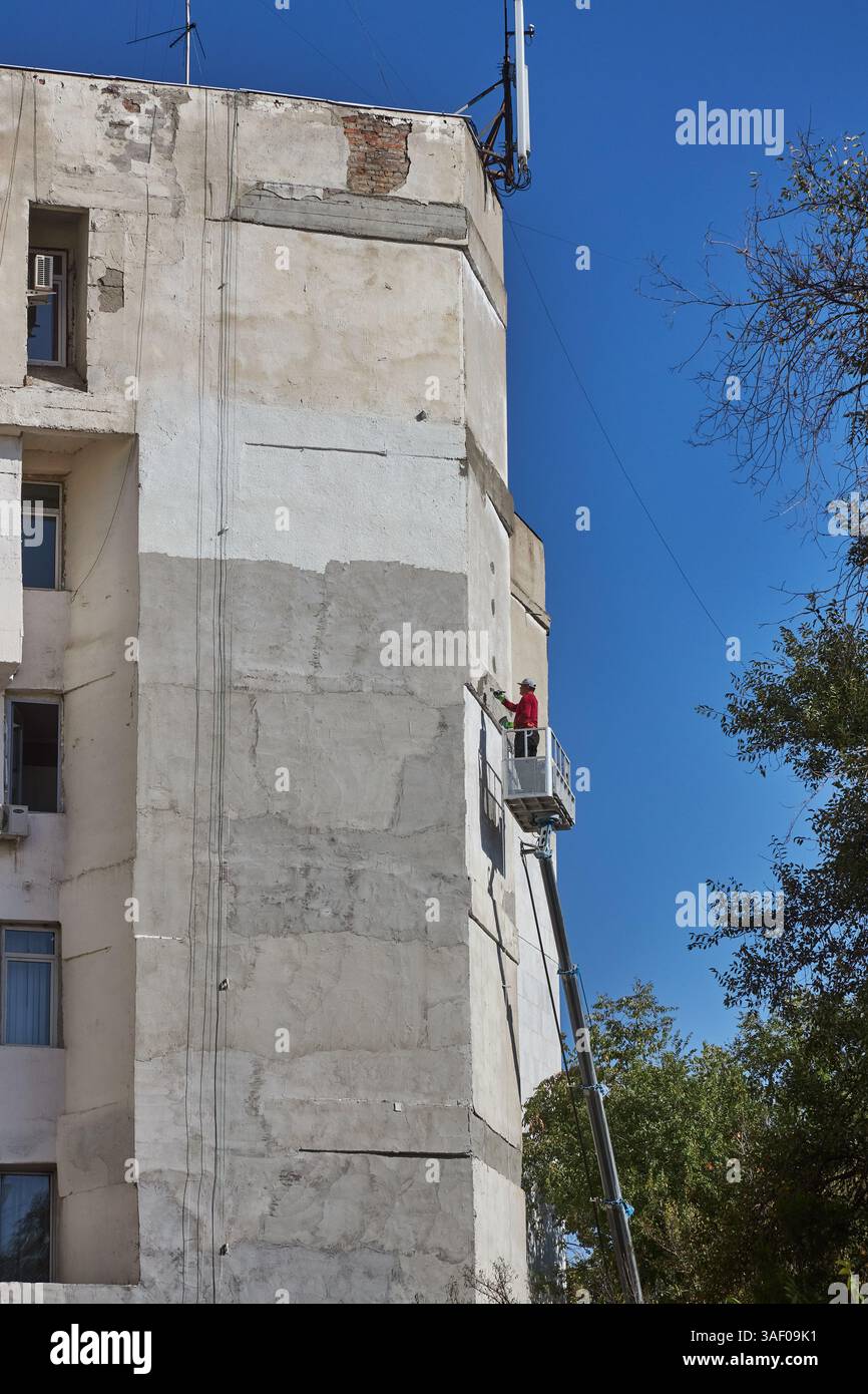Worker using a cherry picker for renovation and repair work on the ...