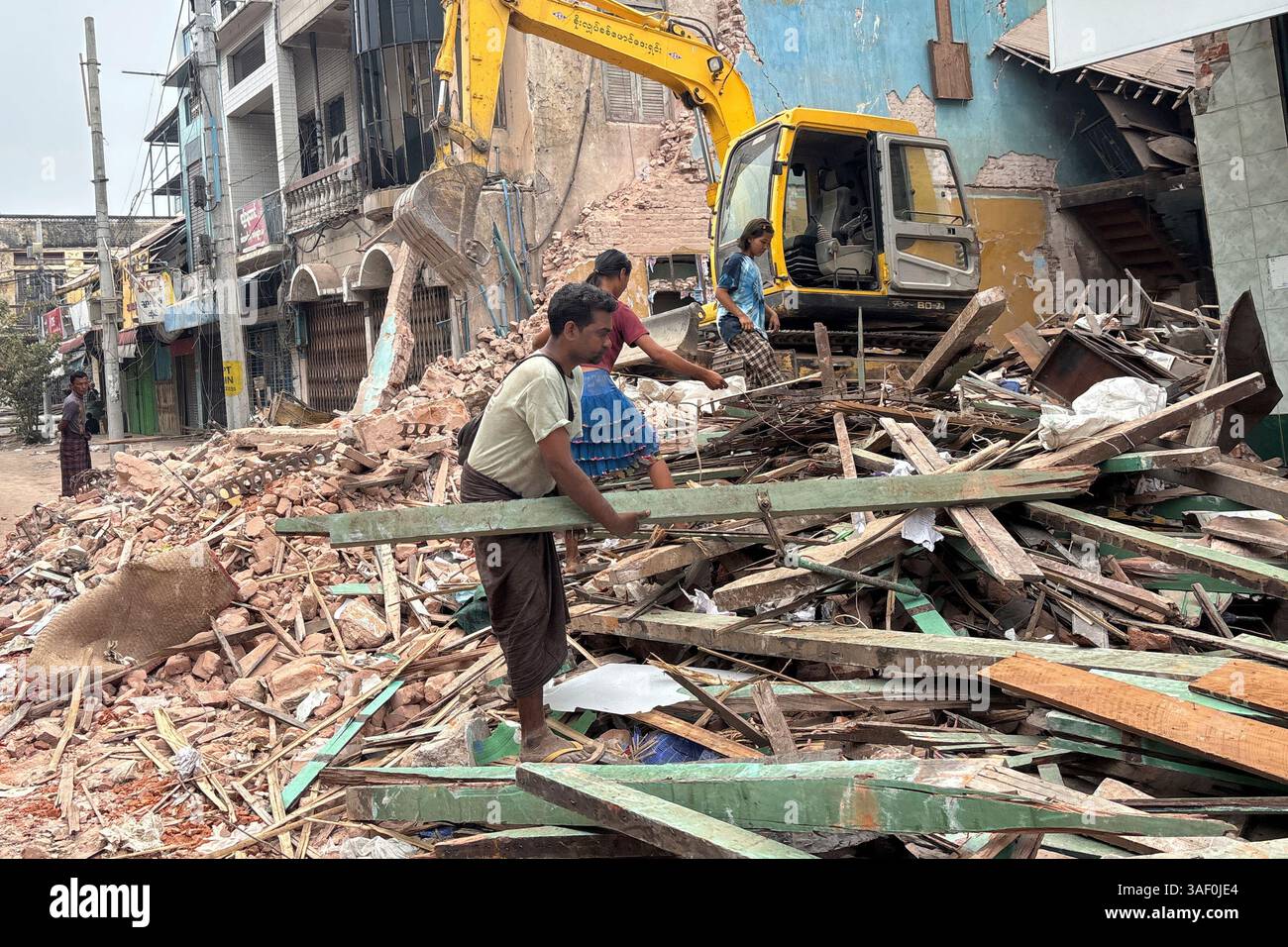 People clean debris from damaged buildings in the aftermath of an ...