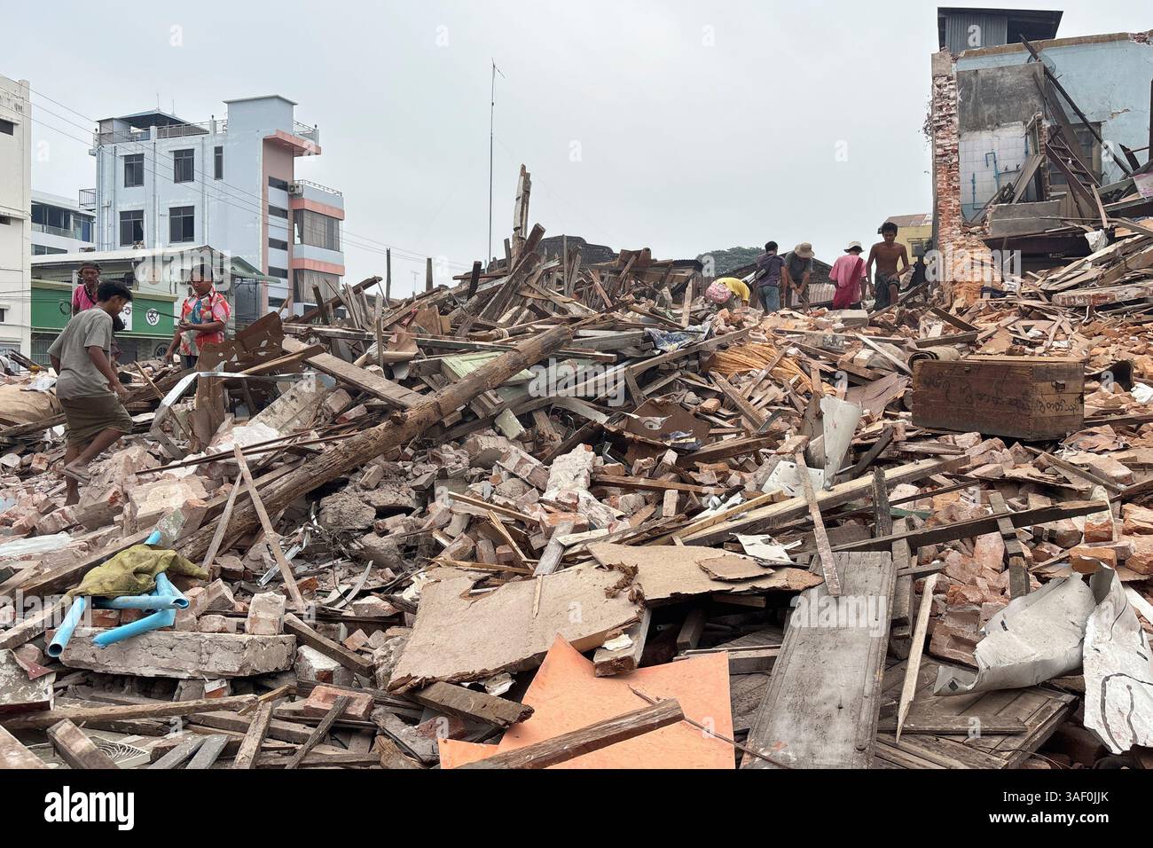 People clean debris from damaged buildings in the aftermath of an ...