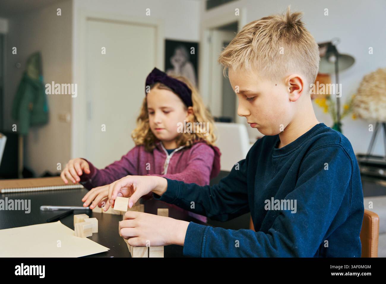 Concentrated children building wooden block tower at home Stock Photo ...