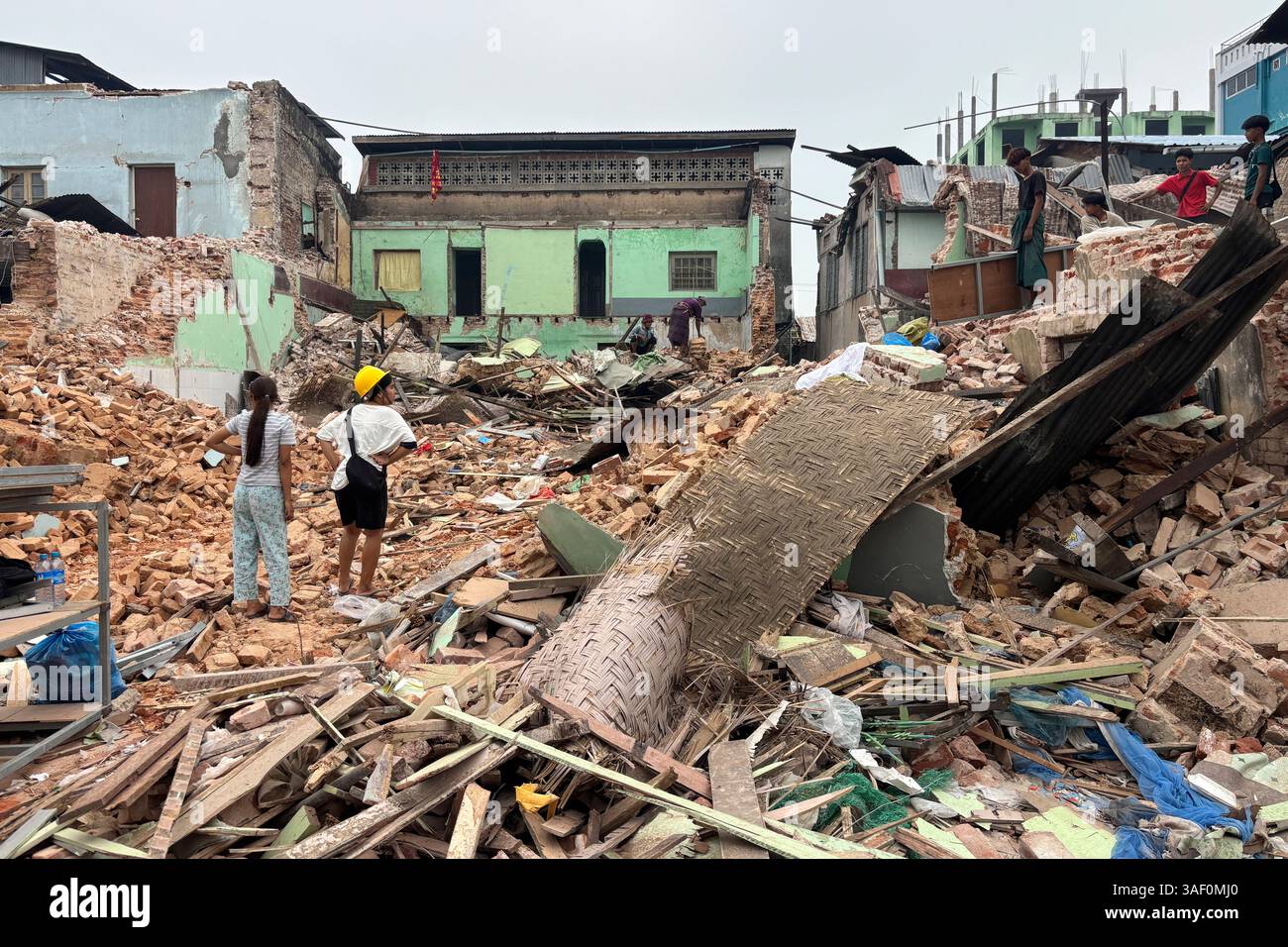 People clean debris from damaged buildings in the aftermath of an ...