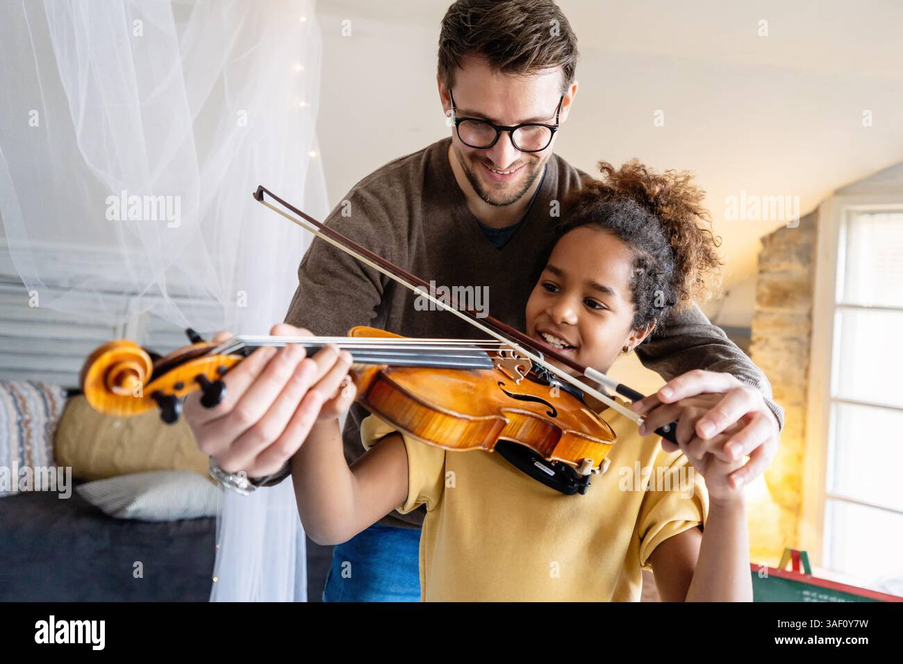 Private music man teacher giving violin lessons to African American girl at home Stock Photo - Alamy