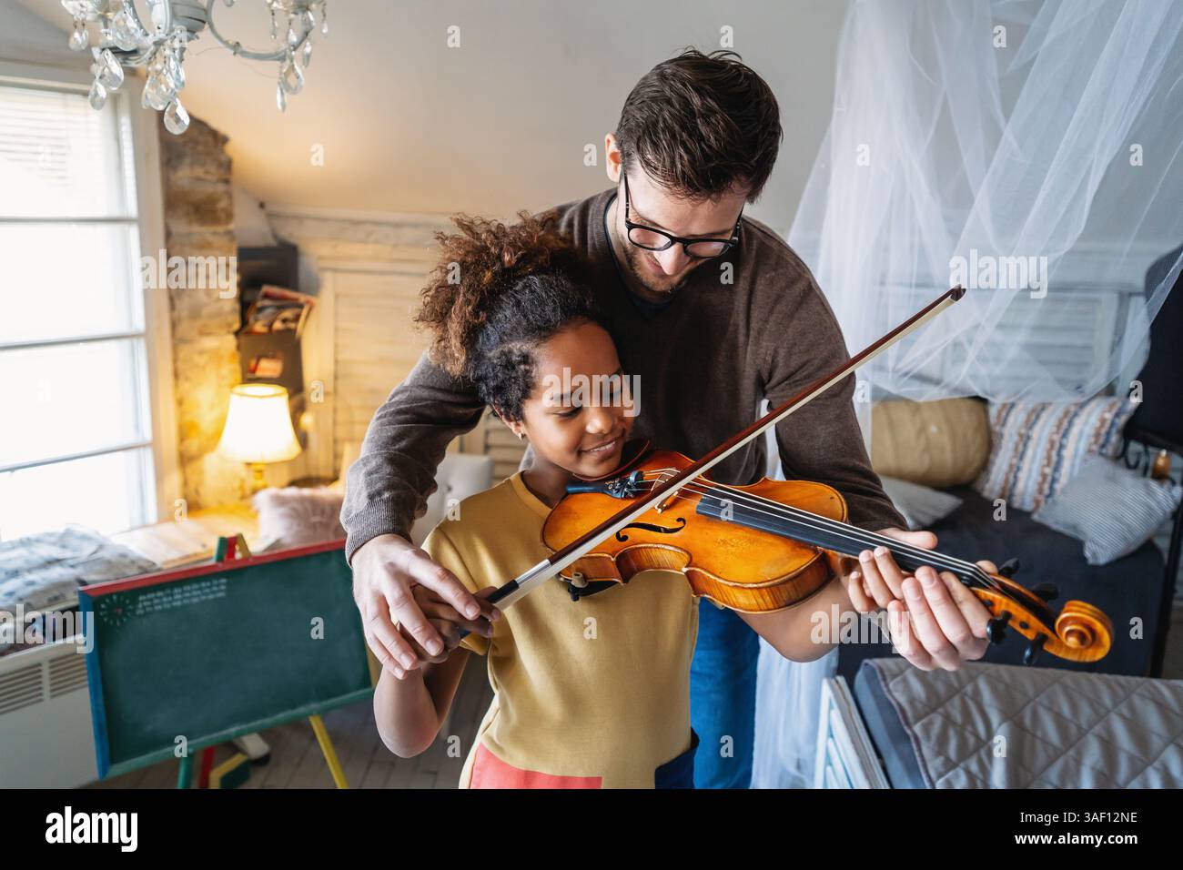Private music man teacher giving violin lessons to African American ...