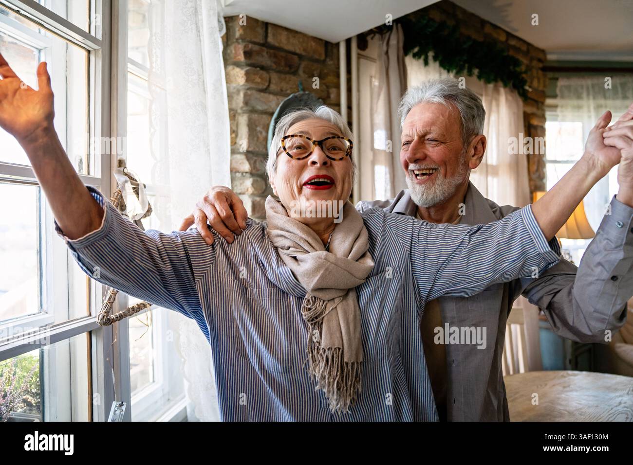 Joyful active old retired romantic senior couple dancing laughing and ...