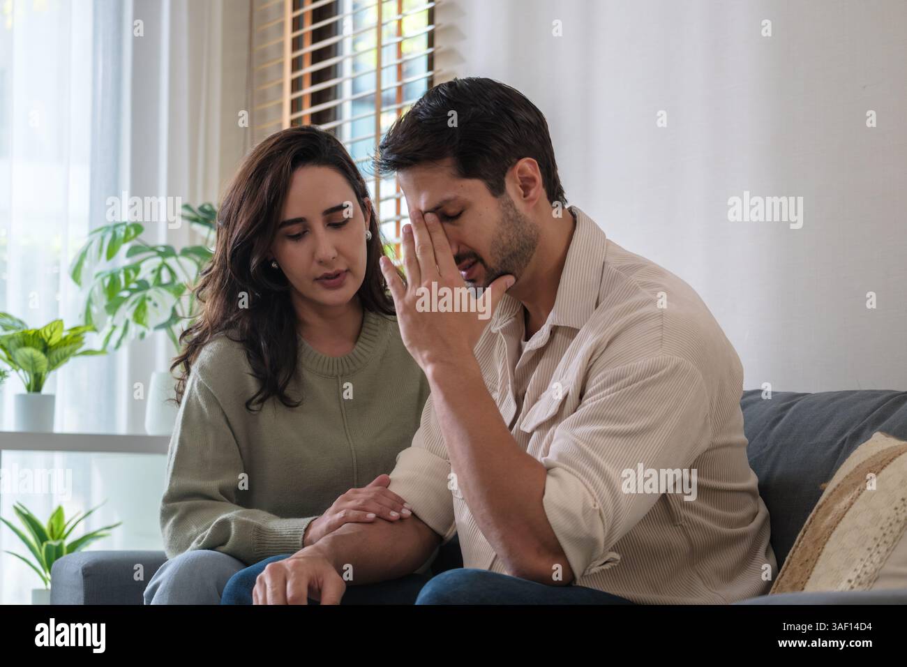 Supportive couple in emotional moment at home as woman struggles with ...