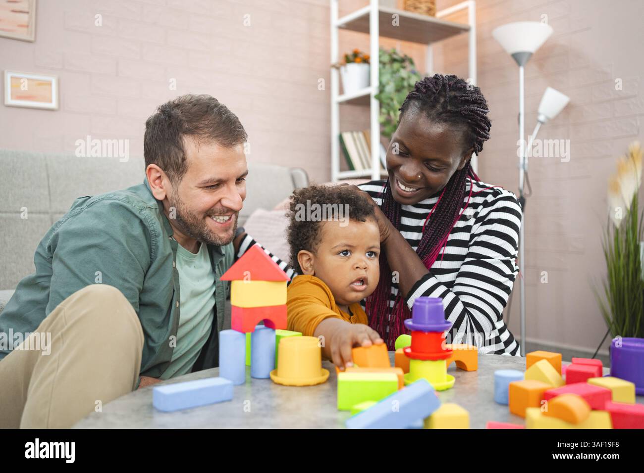 Multiracial family playing with colorful building blocks at home Stock ...