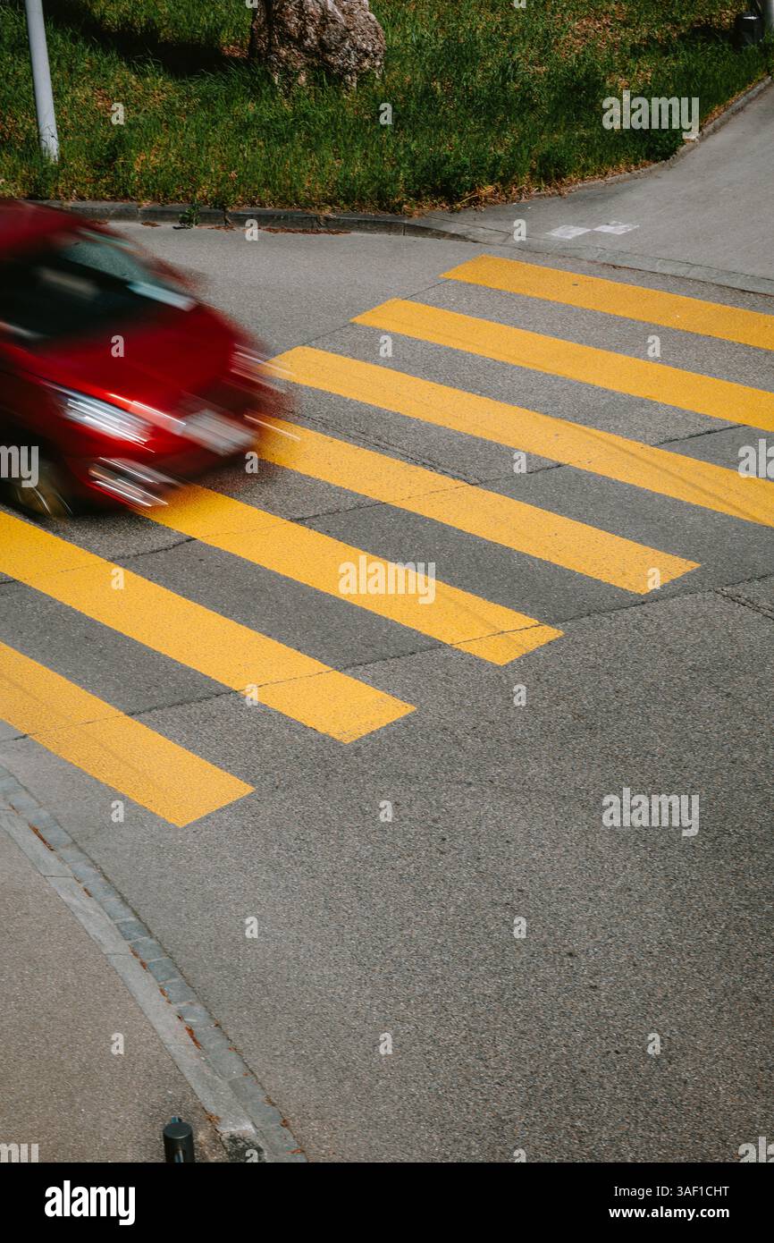 Red blurry car driving over a pedestrian zebra crossing. Pedestrian ...