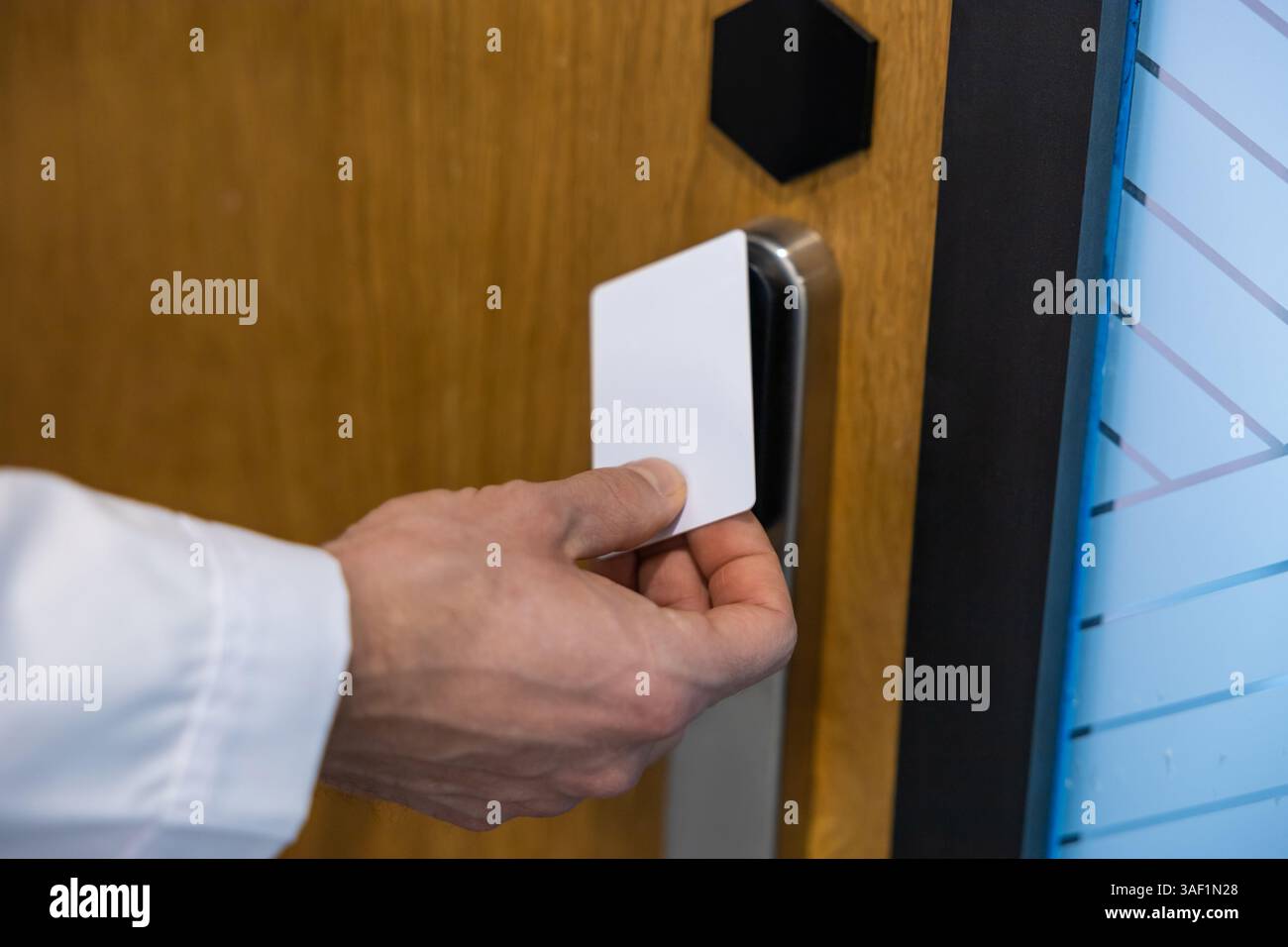 Unrecognizable man using scanner at hospital doorway to open secure lab ...