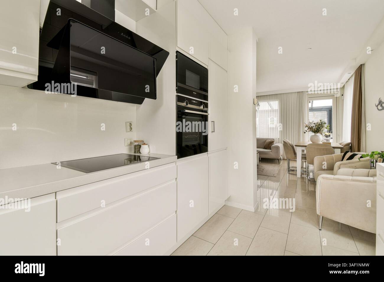 A bright and contemporary kitchen featuring sleek cabinetry, integrated ...