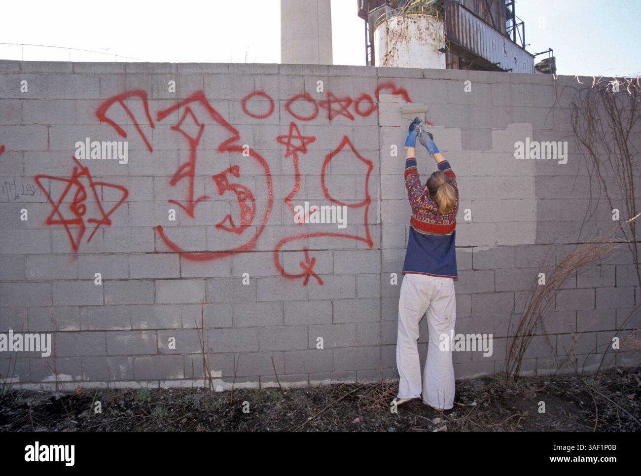 Volunteers painting over graffiti wall hi-res stock photography and ...