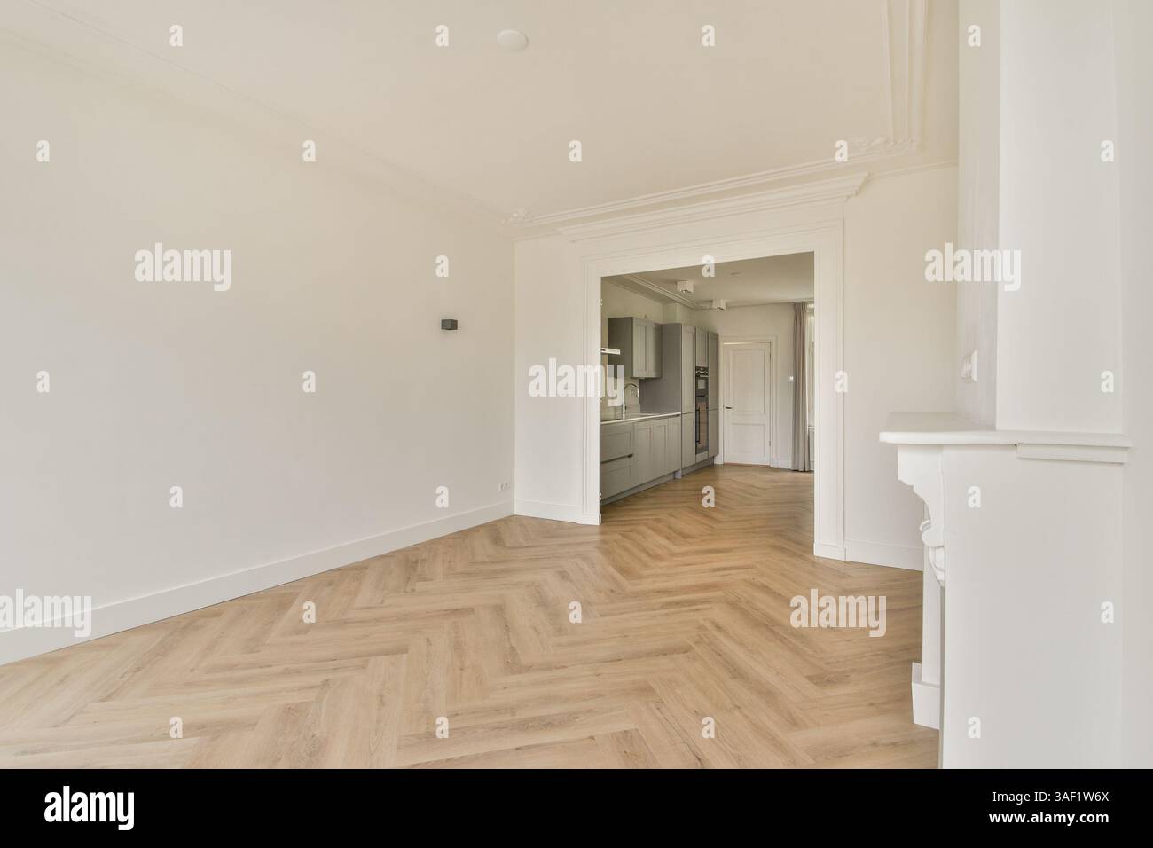 A spacious, modern interior featuring neutral walls and a herringbone ...