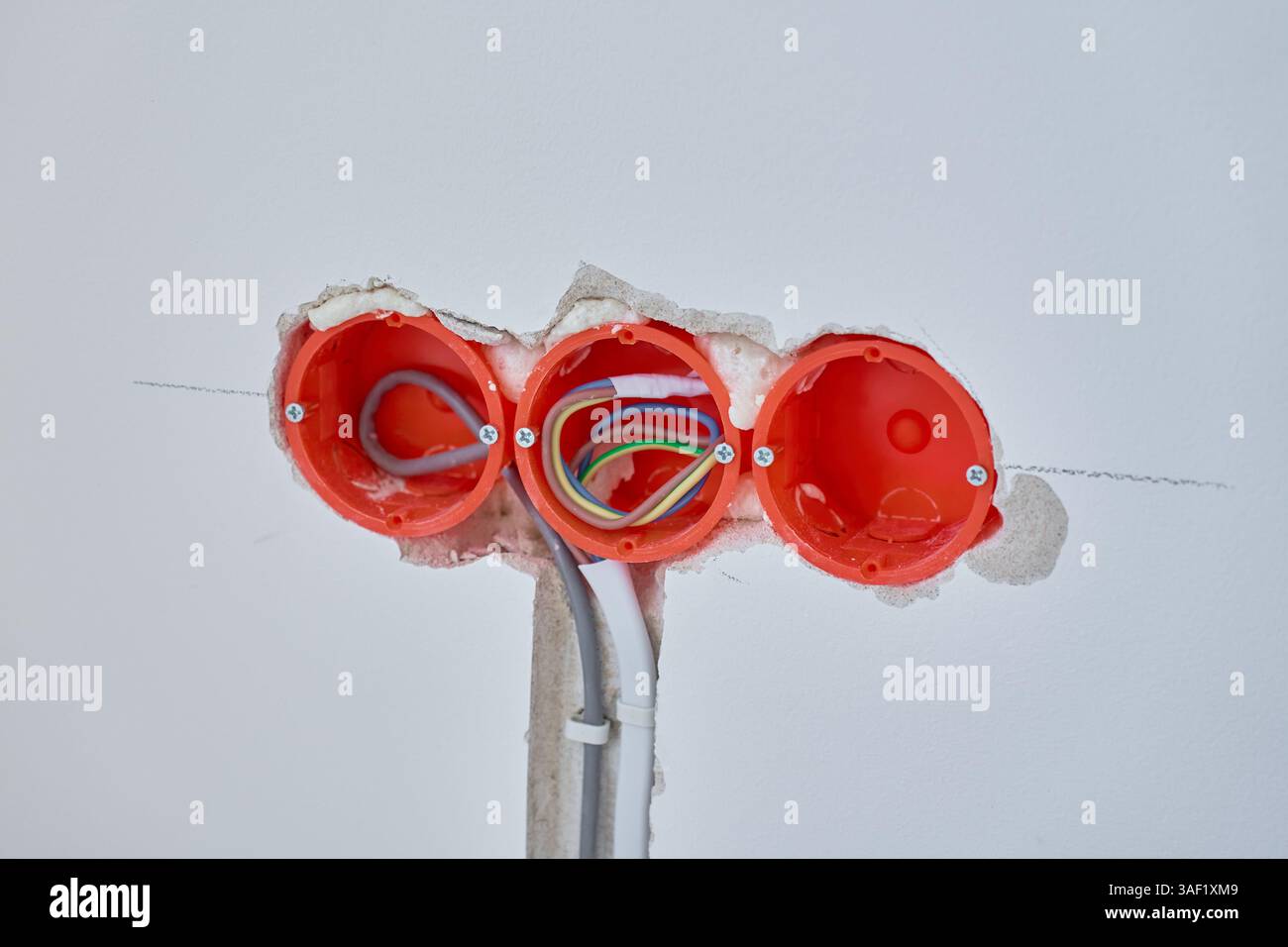Electrical wiring installation during renovation. Three plastic outlet ...